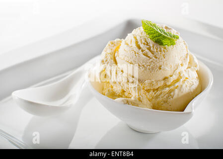 Vanilla milk ice cream ball in a scoop on a gray background. Close-up ...