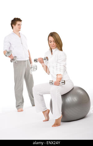 sporty blonde female with fitness ball lie on floor at home interior ...