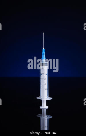 Syringe with needle standing upright Stock Photo - Alamy
