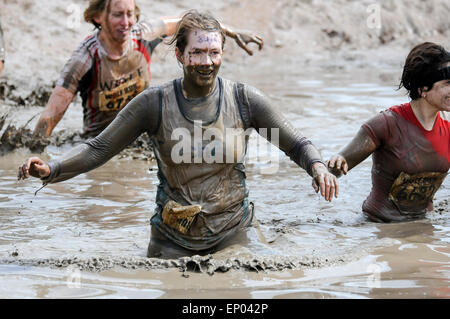 Mud covered women competitors waist deep in mud lake, obstacle course race Stock Photo - Alamy