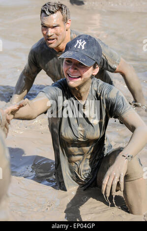 Mud covered young woman competitor waist deep in mud lake, obstacle course race Stock Photo - Alamy