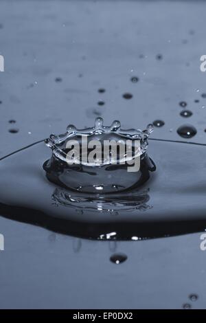 blue water splash crown shape on water surface isolated on white ...