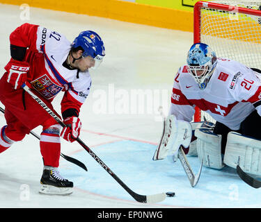 Swiss hockey goalkeeper Reto Berra (L) parades the puck of attacking US ...