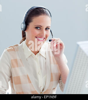 Radiant sales representative woman working on a computer against white ...