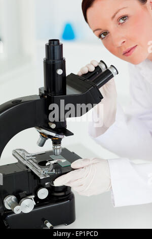 Cute red-haired scientist looking at a test tube in a lab Stock Photo ...