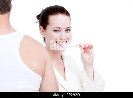 Jolly woman brushing her teeth against a white background Stock Photo ...