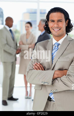 Young businessman standing upright while crossing his arms Stock Photo ...