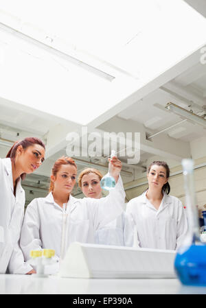 Cute chemistry students looking at a liquid Stock Photo - Alamy