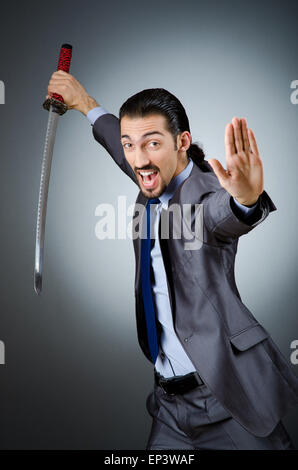 Angry businessman with sword in dark room Stock Photo - Alamy