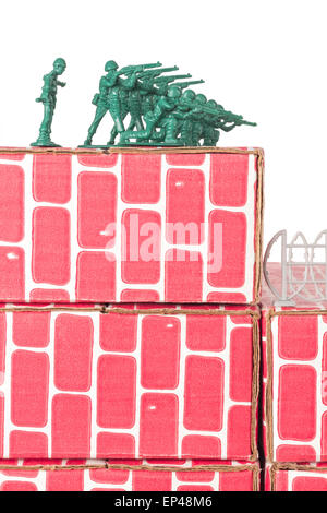 Green army men guarding the top of red cardboard brick base Stock Photo ...