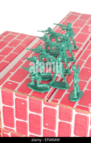 Green army men guarding the top of red cardboard brick base Stock Photo ...