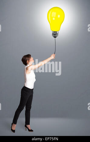 Woman holding a lightbulb balloon Stock Photo - Alamy