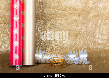 Rolls of multicolored wrapping paper with streamer for gifts on gold ...