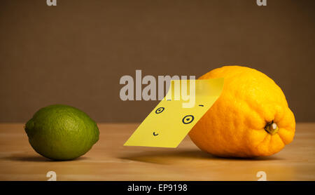 Lemon with post-it note looking at lime Stock Photo - Alamy