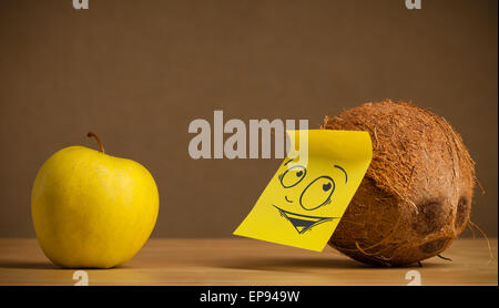 Coconut with post-it note looking curiously at citrus fruits Stock ...