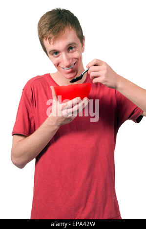 Handsome young man holding bowl of popcorn, smiling amazed and pointing ...