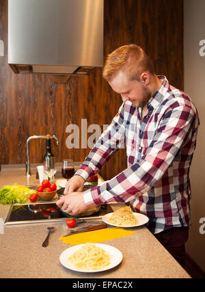 Handsome man cooking pasta at home Stock Photo - Alamy