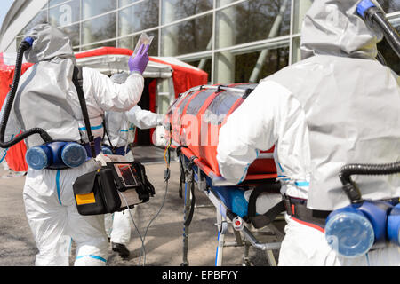 Biohazard team pushing stretcher towards chamber Stock Photo - Alamy