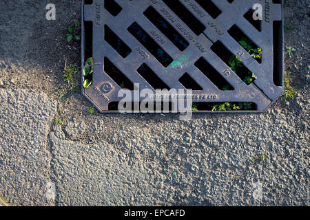 Metal grill drain cover in a pathway of asphalt and pavement grey Stock ...