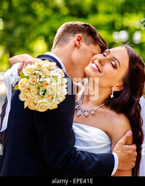 Groom kissing bride on shoulder Stock Photo - Alamy