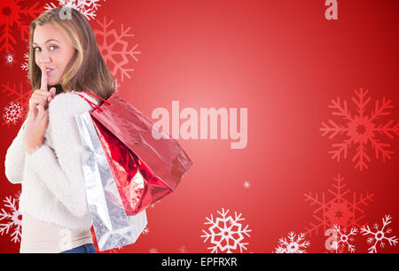 Composite image of pretty blonde keeping a secret holding bags Stock ...