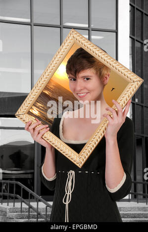 Happy woman holding frame of photo at home Stock Photo - Alamy