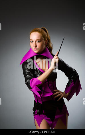 Female magician doing tricks on grey background Stock Photo - Alamy