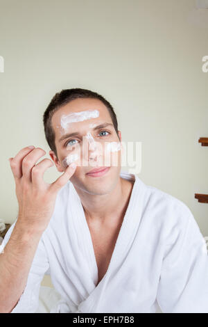 Relaxed man creams his face Stock Photo - Alamy