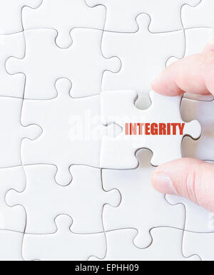 Piece of missing jigsaw puzzle with integrity text on a black ...