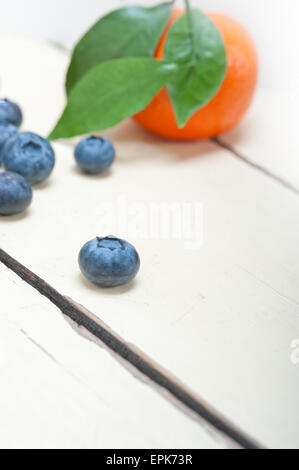 tangerine and blueberry on white table Stock Photo - Alamy