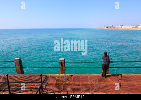Man leaning on railings on sea front Stock Photo - Alamy