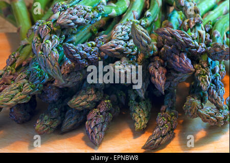 Wooden board with fresh green asparagus and different ingredients on ...
