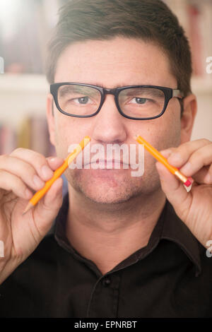 Man holding pencil and writing on a paper in the diary Stock Photo - Alamy