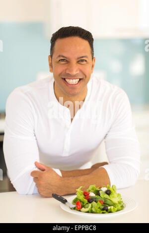 Happy adult guy having healthy lunch with veggies at the home Stock ...