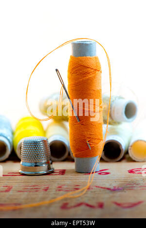 Orange Thread and Thimble on Orange and White Striped Fabric Stock ...