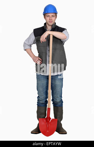 Builder stood with spade Stock Photo - Alamy