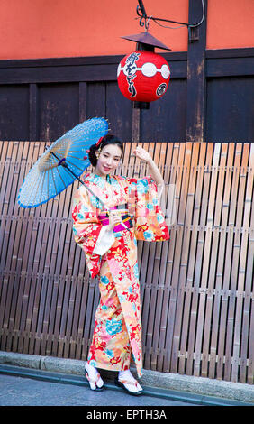 girl dressed as a geisha holding a parasol in Japan Stock Photo - Alamy