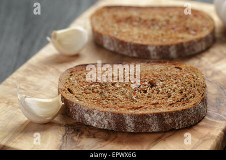 Snack toast grated with garlic on a wooden table Stock Photo - Alamy