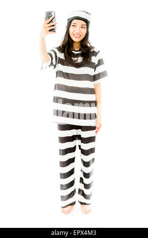 A prisoner in prison using a mobile phone behind bars in a cell Stock ...