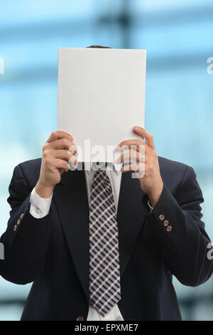 Businessman holding and hiding behind card with smiley face emoticon ...
