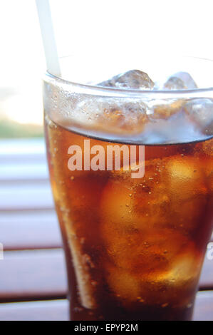A thirst-quenching glass of cola filled with ice cubes, epitomizing ...