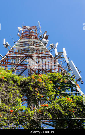 Vertical of telecommunication tower with blue sky and white clouds ...