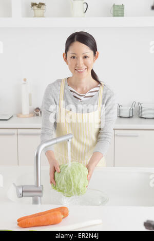 Woman washing cabbage in an open kitchen Stock Photo - Alamy