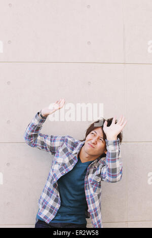 Scared man with his hands against the wall watching and waiting for ...