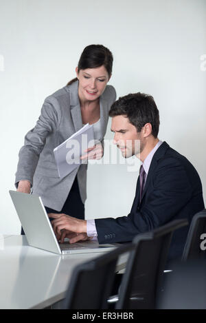 selective focus of businesswoman helping focused colleague with work at ...