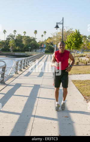 Man jogging along the river walk practicing social distancing Stock ...
