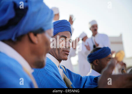 A group of Berber men in traditional blue dress are standing in the ...