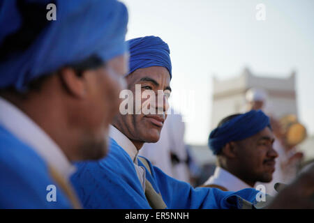 A group of Berber men in traditional blue dress are standing in the ...