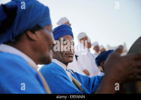 A group of Berber men in traditional blue dress are standing in the ...