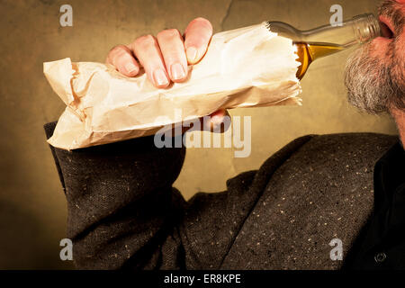 A bottle of alcohol in a brown paper bag isolated on a white Stock ...